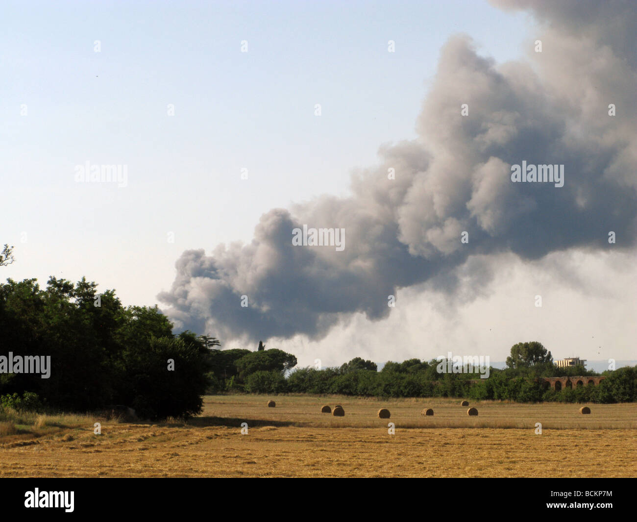 long black smoke trail over rural green landscape Stock Photo - Alamy