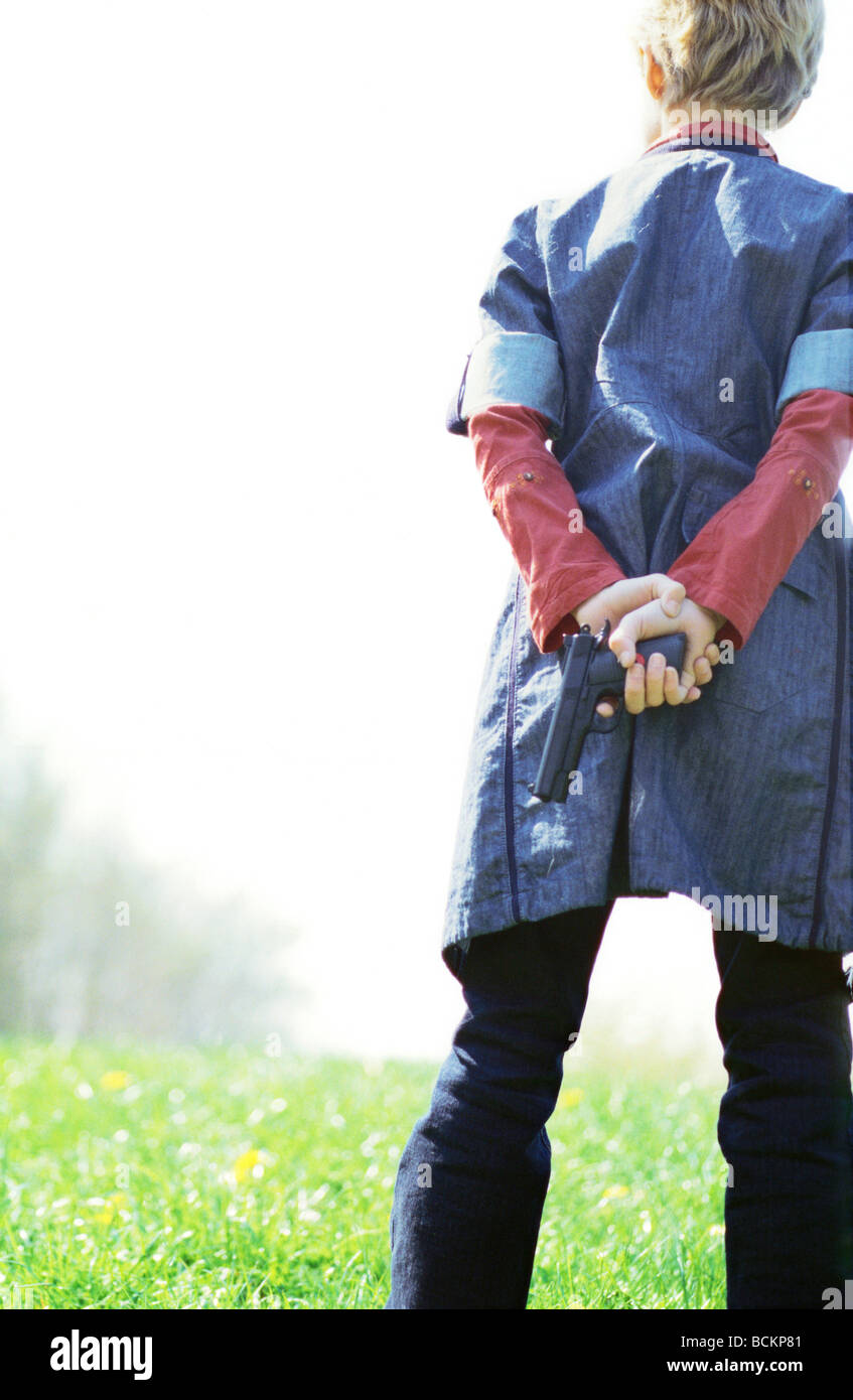 Child holding gun behind back Stock Photo - Alamy