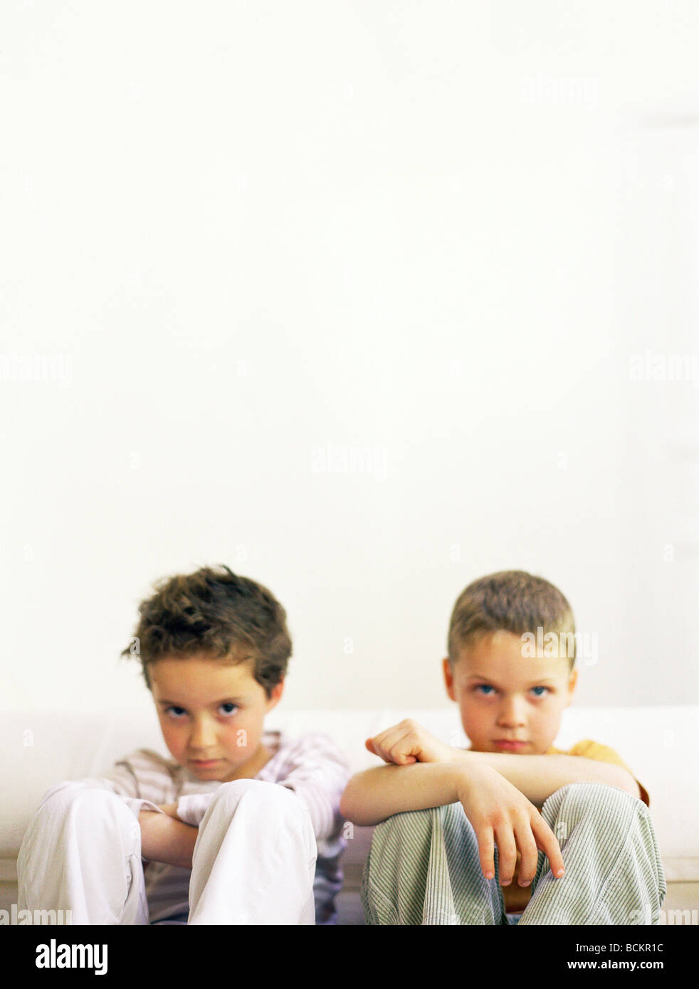 Two children sitting side by side Stock Photo - Alamy