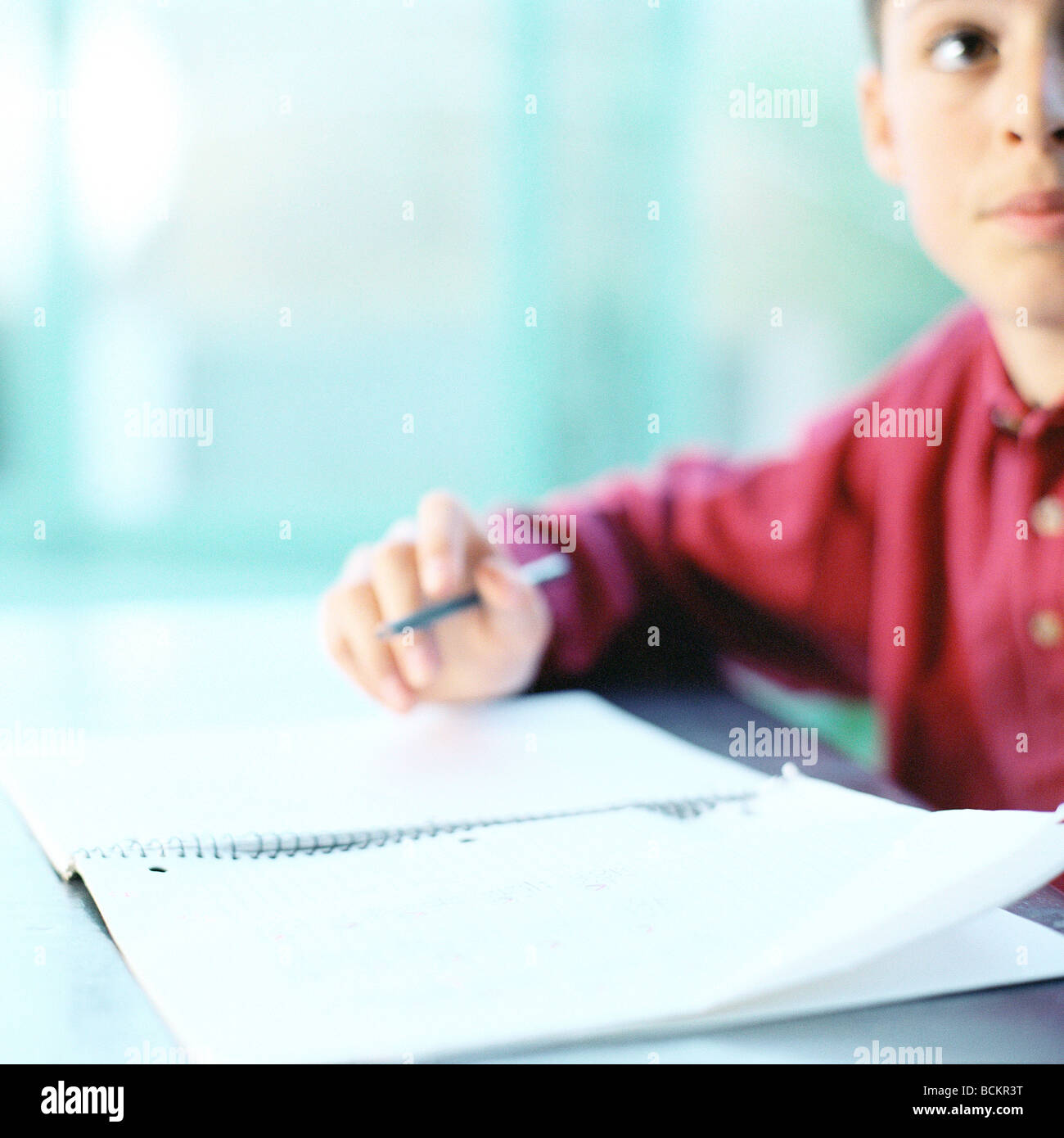 Boy writing at table Stock Photo - Alamy