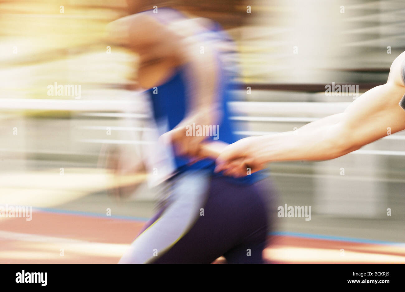Runner passing on relay baton, blurred motion Stock Photo - Alamy