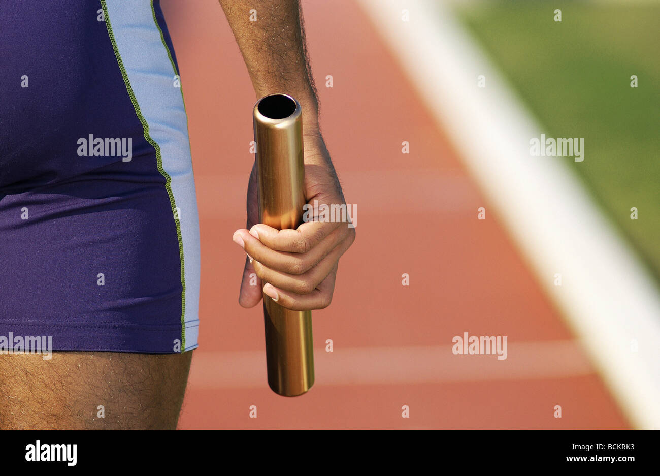 Athlete holding relay baton, partial view, close-up Stock Photo - Alamy