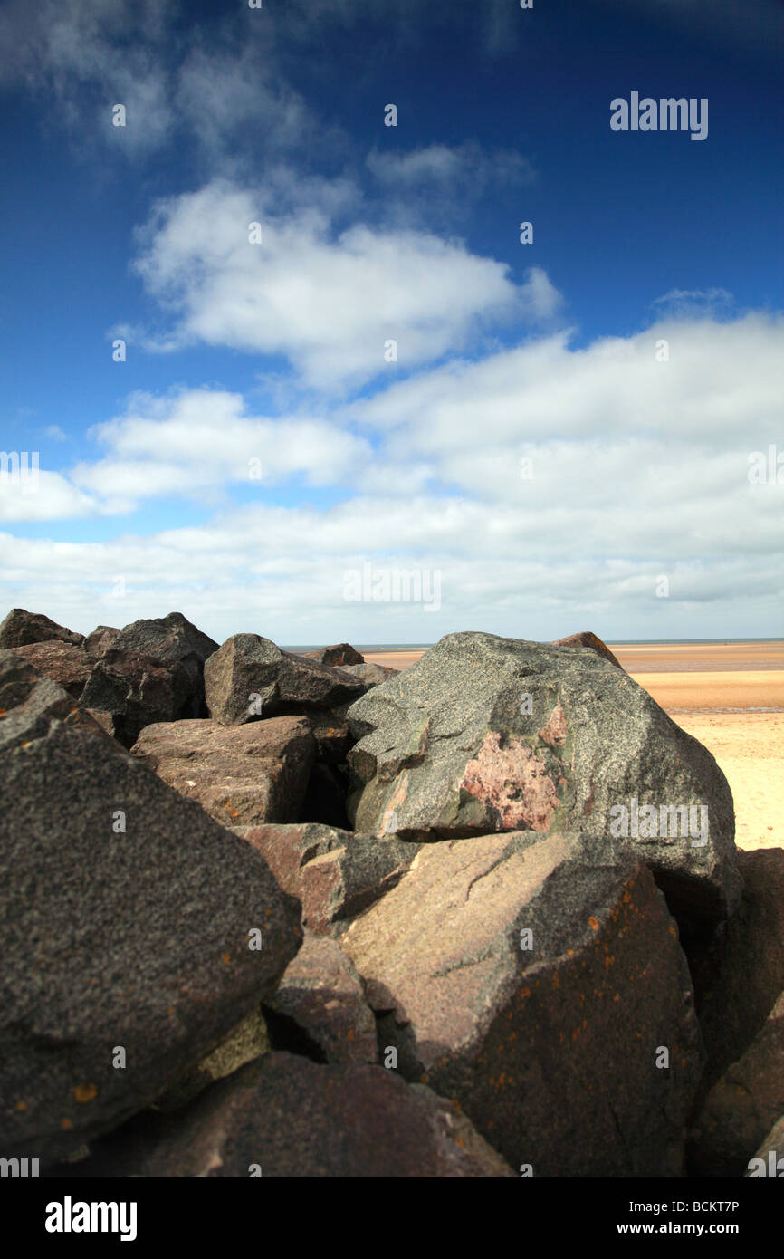 Beach defences on a sandy beach with a blue sky above Stock Photo - Alamy
