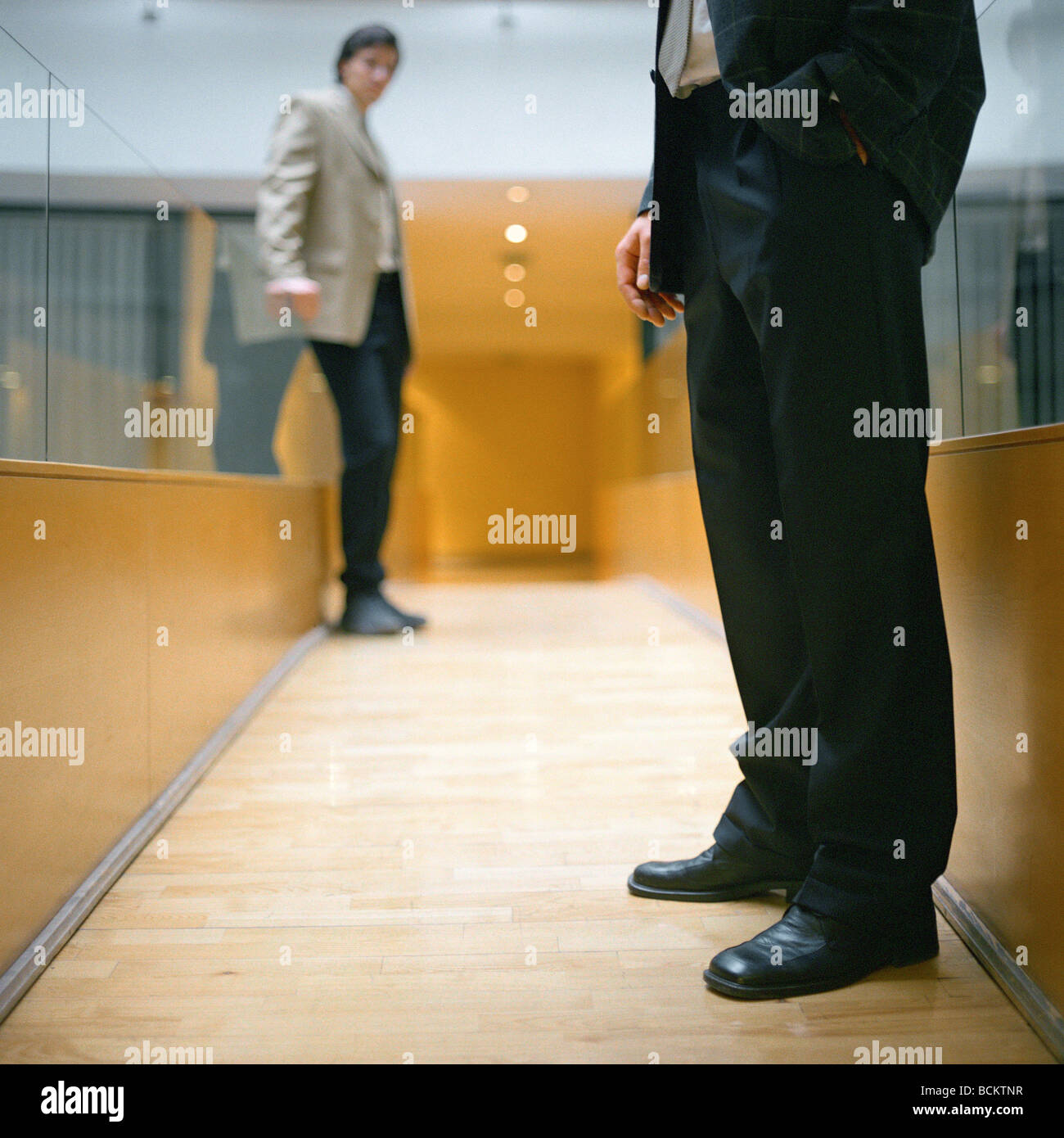 Businessmen standing, interior Stock Photo - Alamy