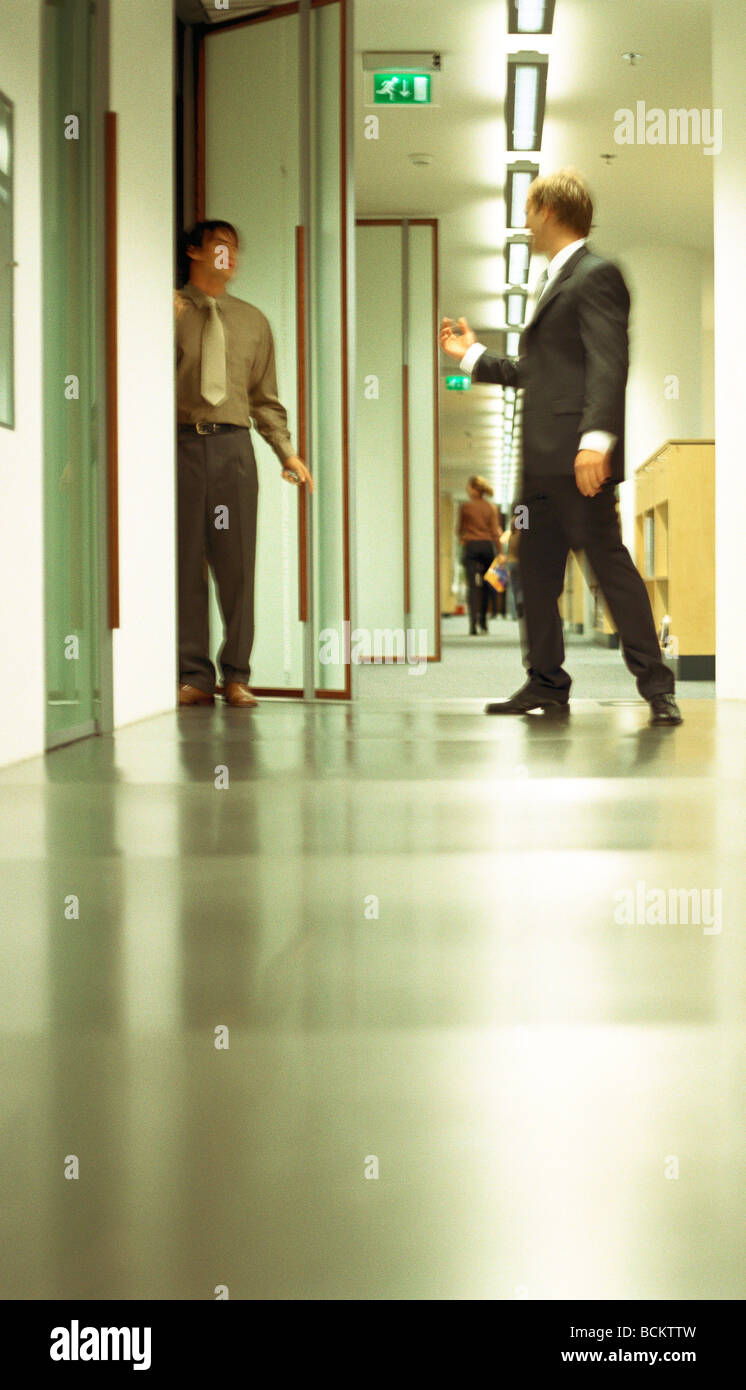 Businessmen talking in hallway Stock Photo - Alamy