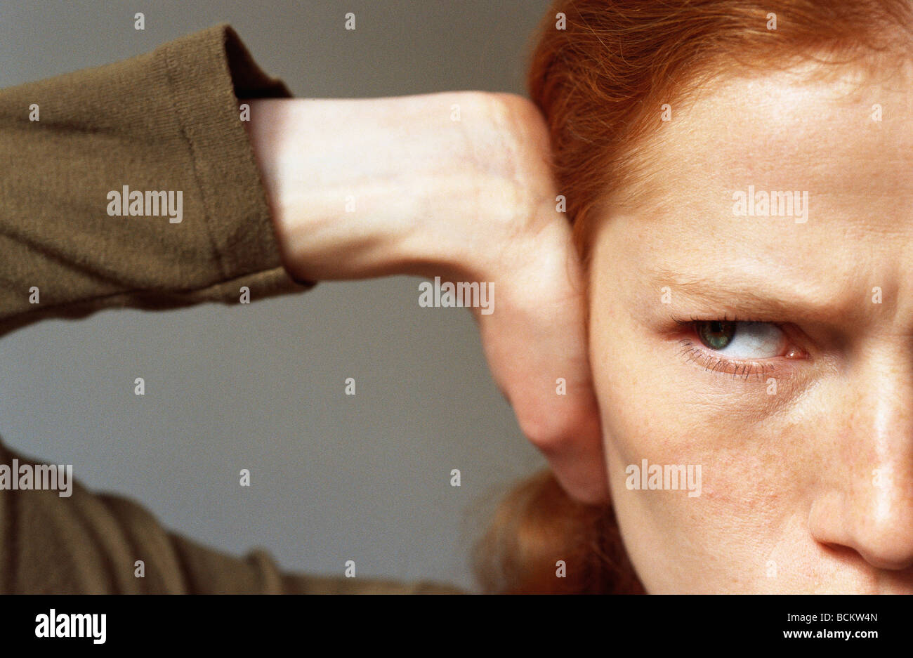 Young woman covering ear with hand, close-up Stock Photo - Alamy