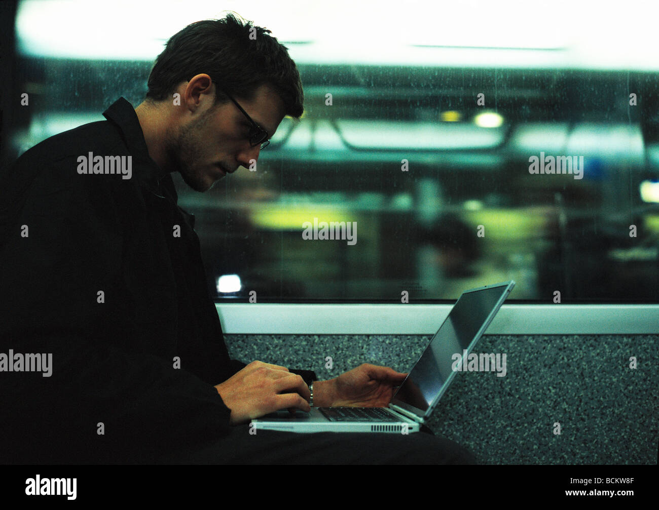 Man using laptop computer, side view Stock Photo - Alamy