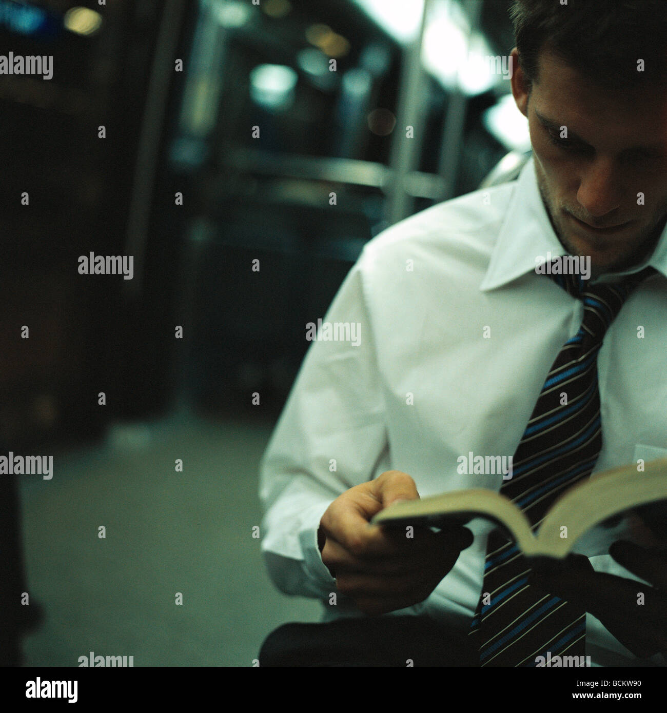Man reading in subway car Stock Photo - Alamy
