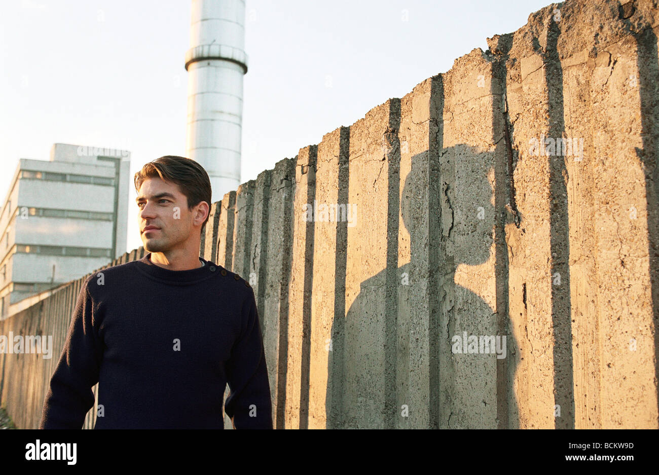 Man walking along wall Stock Photo - Alamy