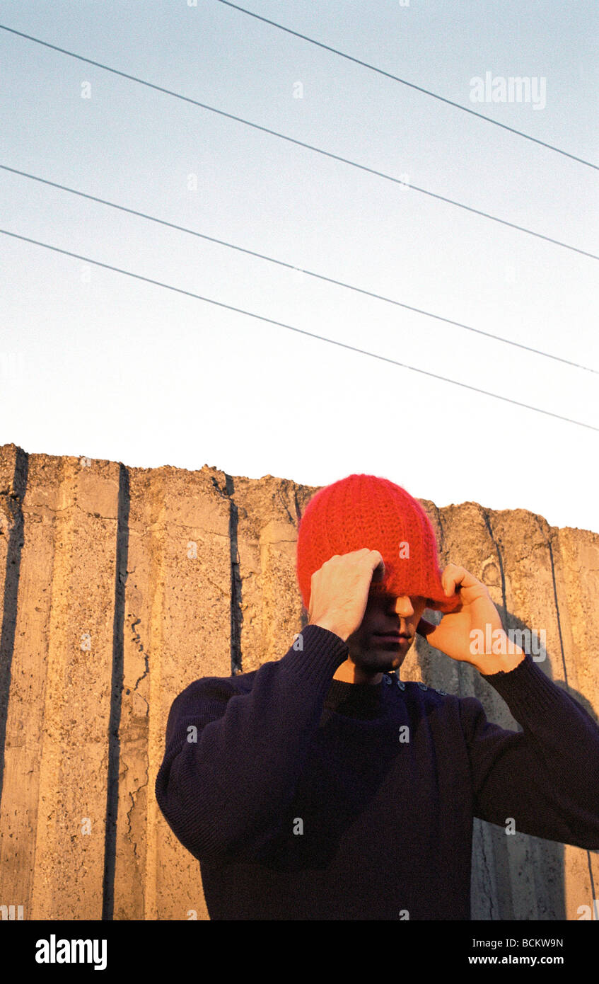 Man adjusting hat Stock Photo - Alamy