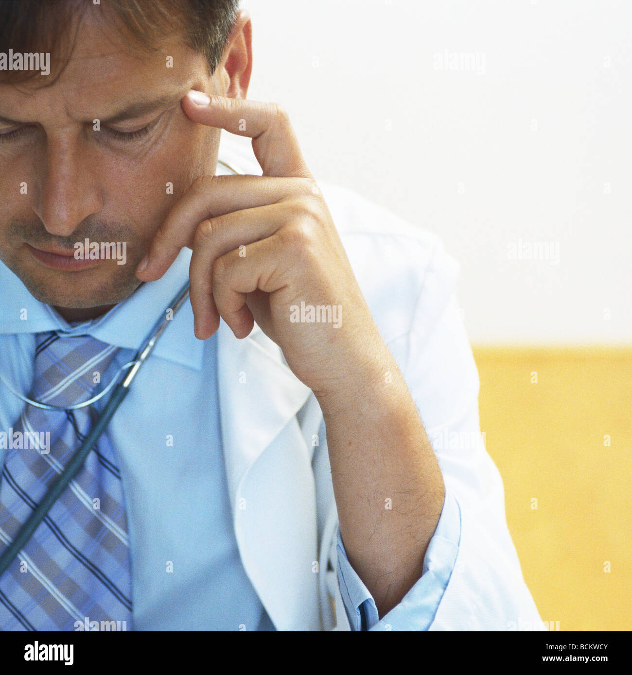 Doctor wearing stethoscope, looking down, close-up Stock Photo - Alamy