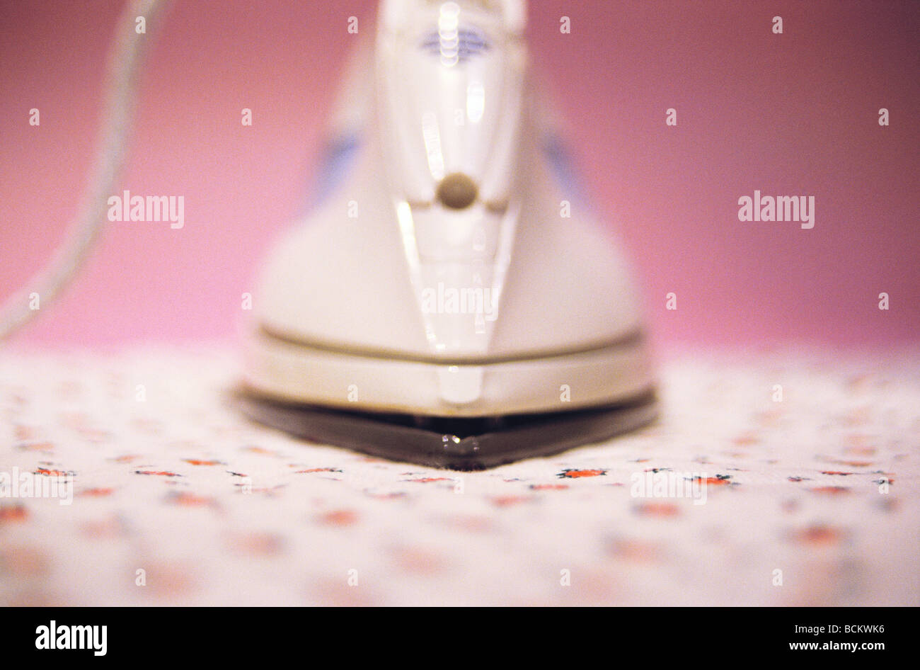Iron on ironing board, surface level view Stock Photo - Alamy