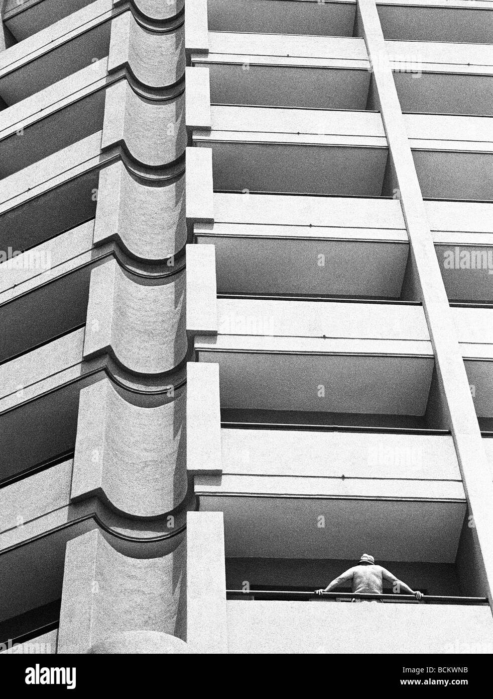 Facade of apartment building, person leaning against railing, b&w Stock ...