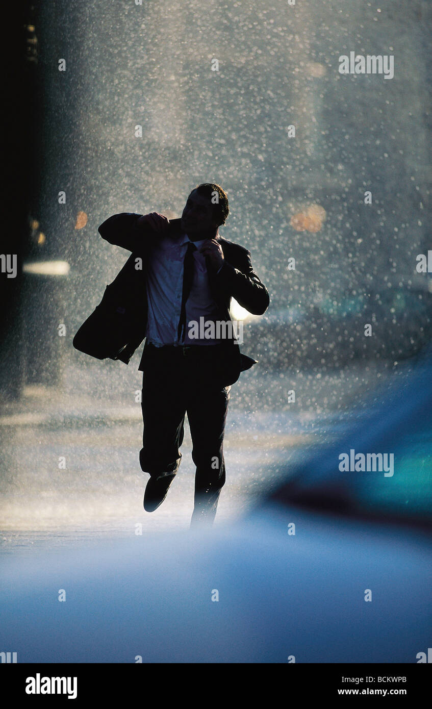 Businessman running in rain Stock Photo - Alamy