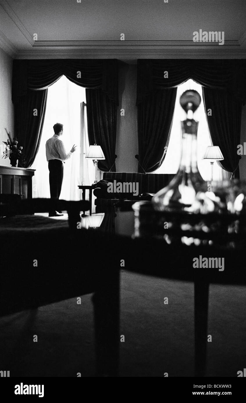 Man standing at window, interior, b&w Stock Photo - Alamy