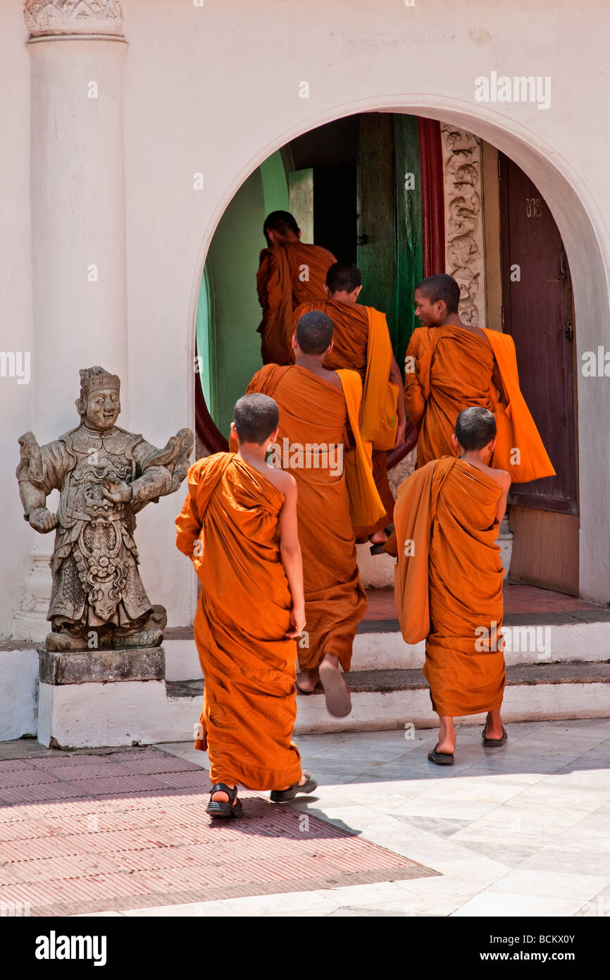 Thailand. Saffron-robed Buddhist monks enter the Phra Pathom Chedi ...