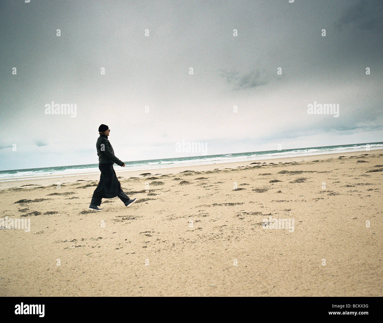 Person walking on beach, side view Stock Photo - Alamy