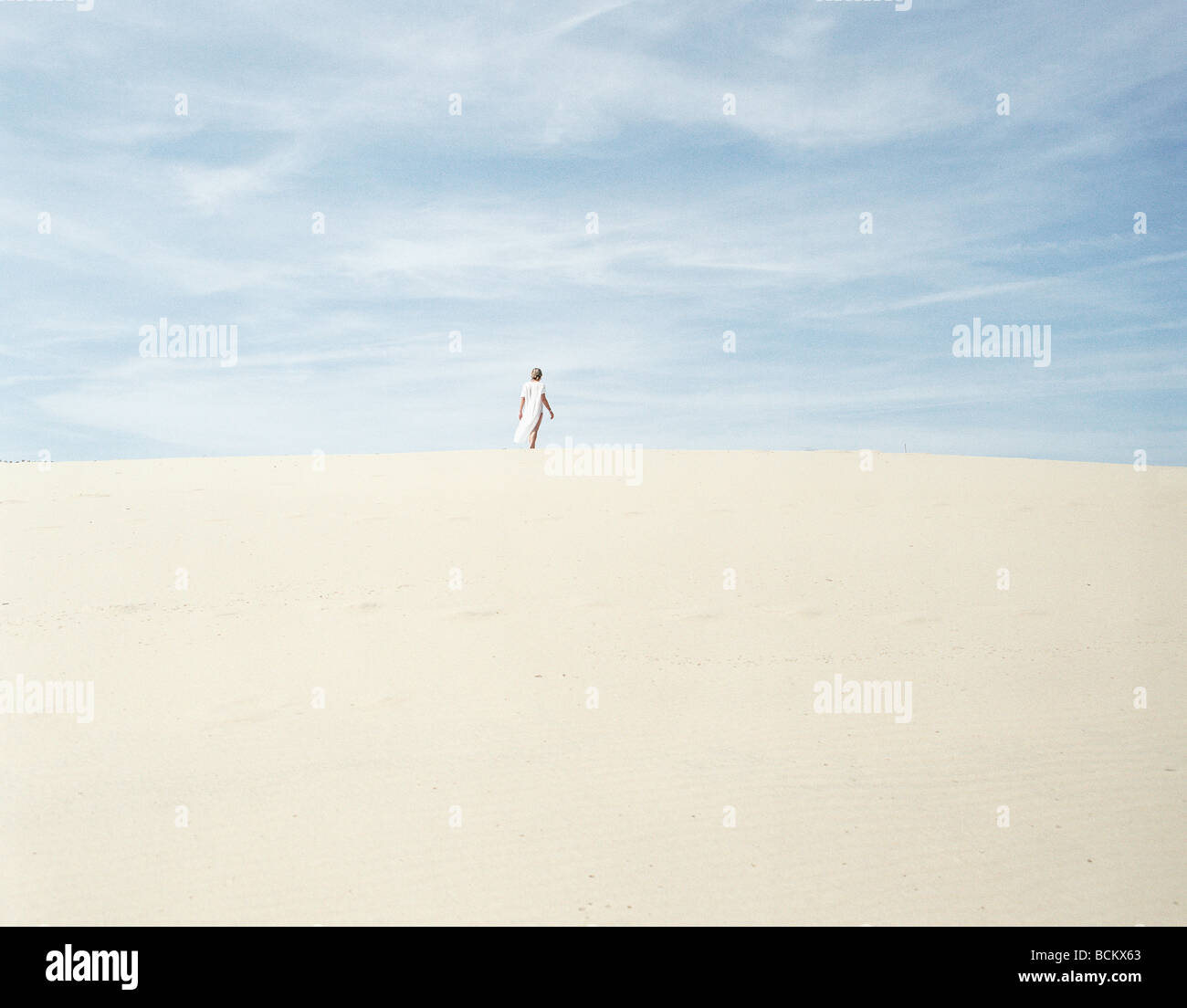 Woman standing on sand, in distance Stock Photo - Alamy