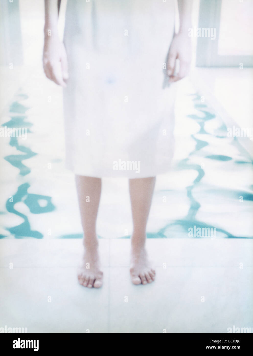Woman standing by pool, waist down Stock Photo - Alamy