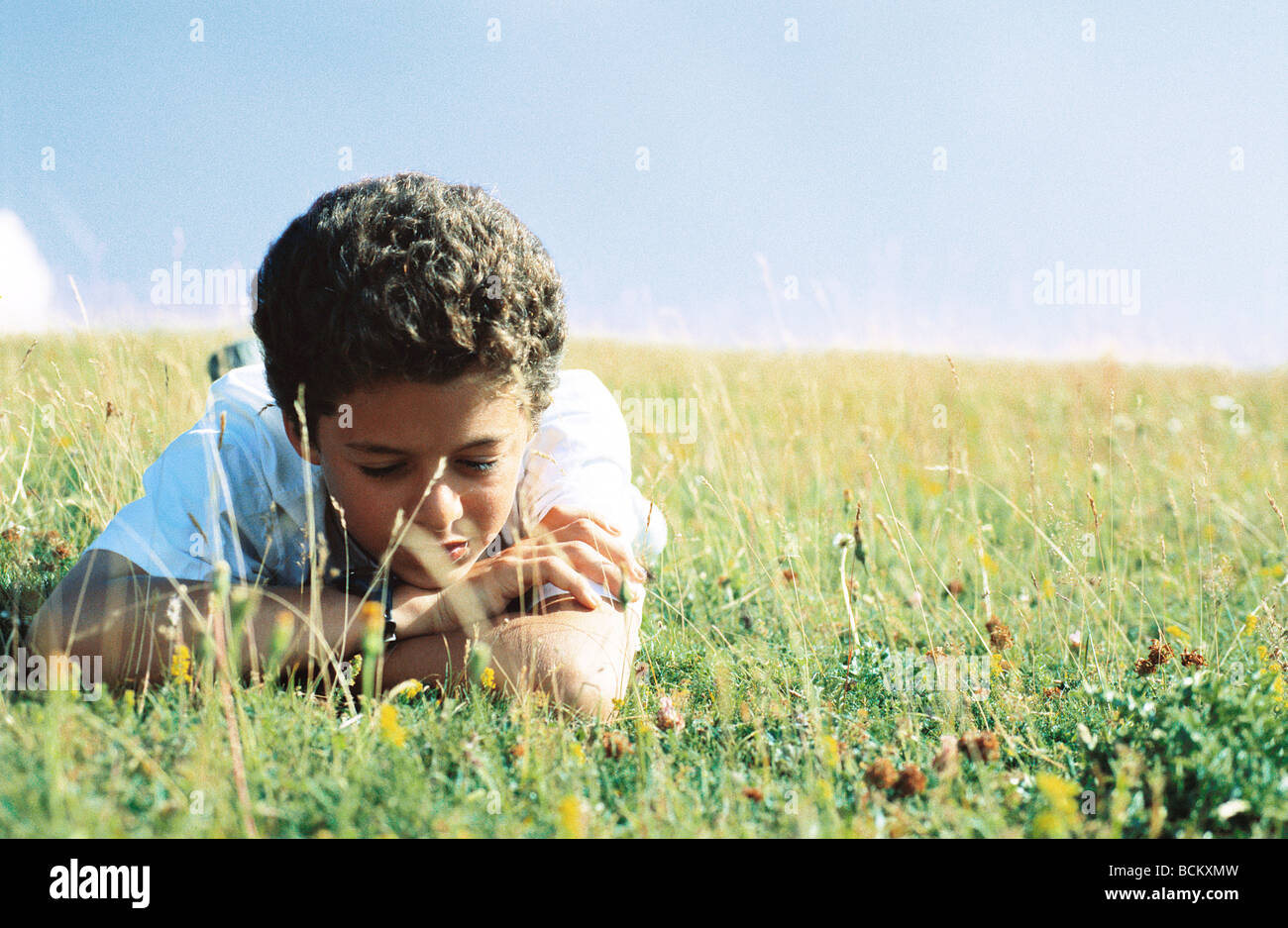 Boy lying on grass arms hi-res stock photography and images - Alamy