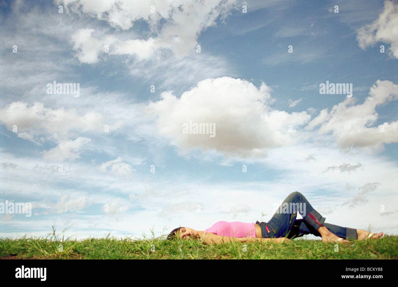 Woman lying on back on grass Stock Photo - Alamy