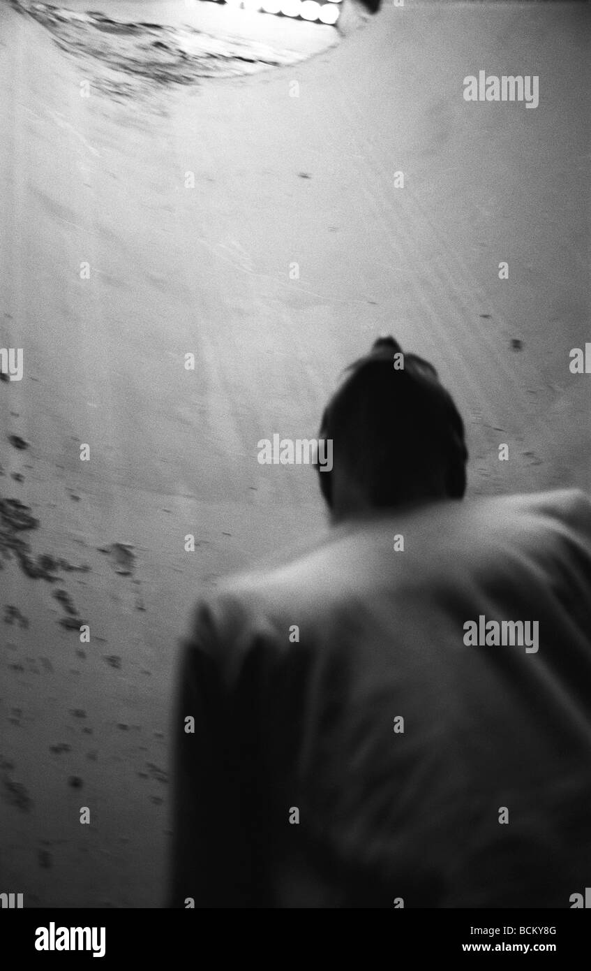 Person standing next to wall looking up, low angle view, b&w Stock ...