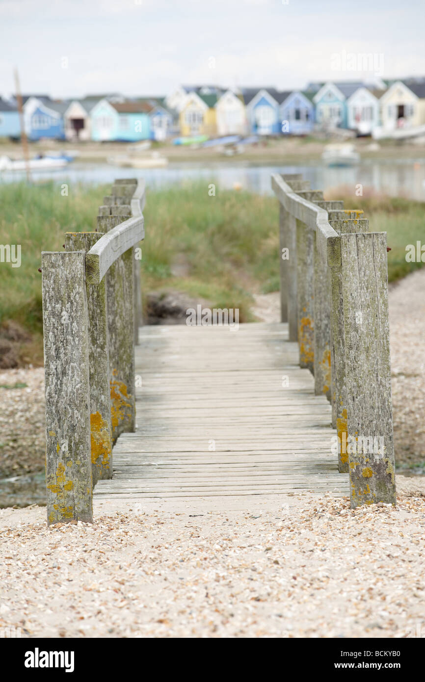 Wooden foot bridge with beach huts in background Stock Photo - Alamy