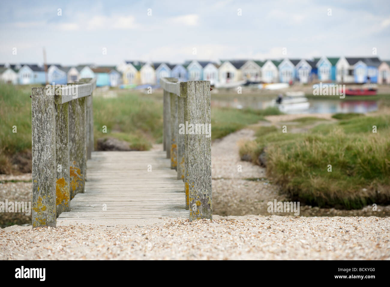 Wooden foot bridge with beach huts in background Stock Photo - Alamy
