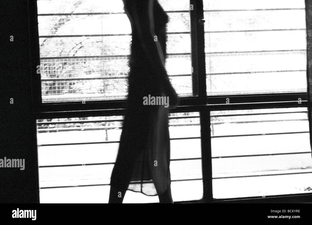 Woman walking in front of window, partial view, b&w Stock Photo - Alamy