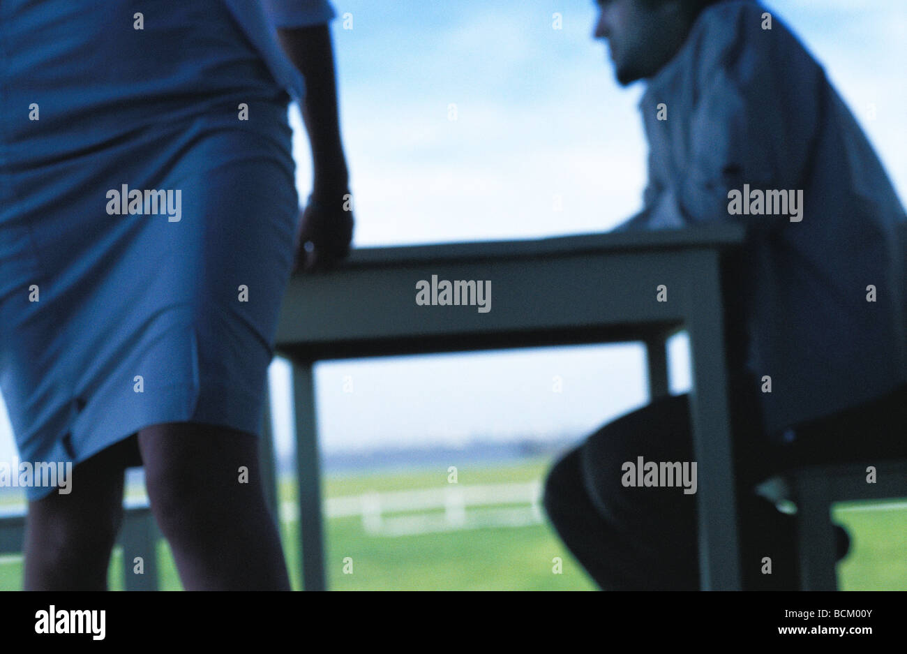Woman walking away from table where man is sitting Stock Photo - Alamy