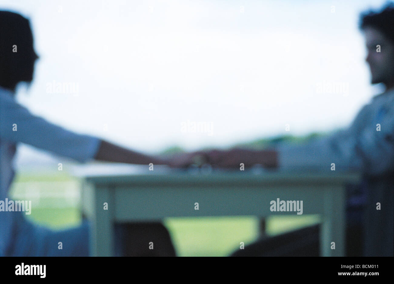Couple holding hands across table Stock Photo - Alamy
