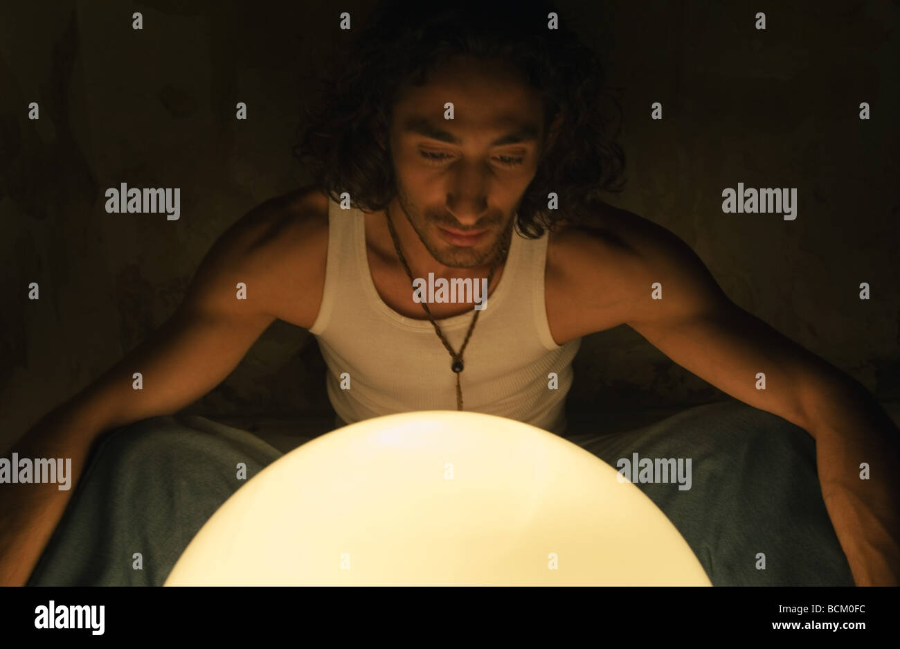 Man looking at glowing orb Stock Photo - Alamy