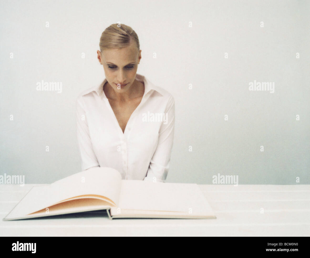Woman sitting and reading book Stock Photo - Alamy