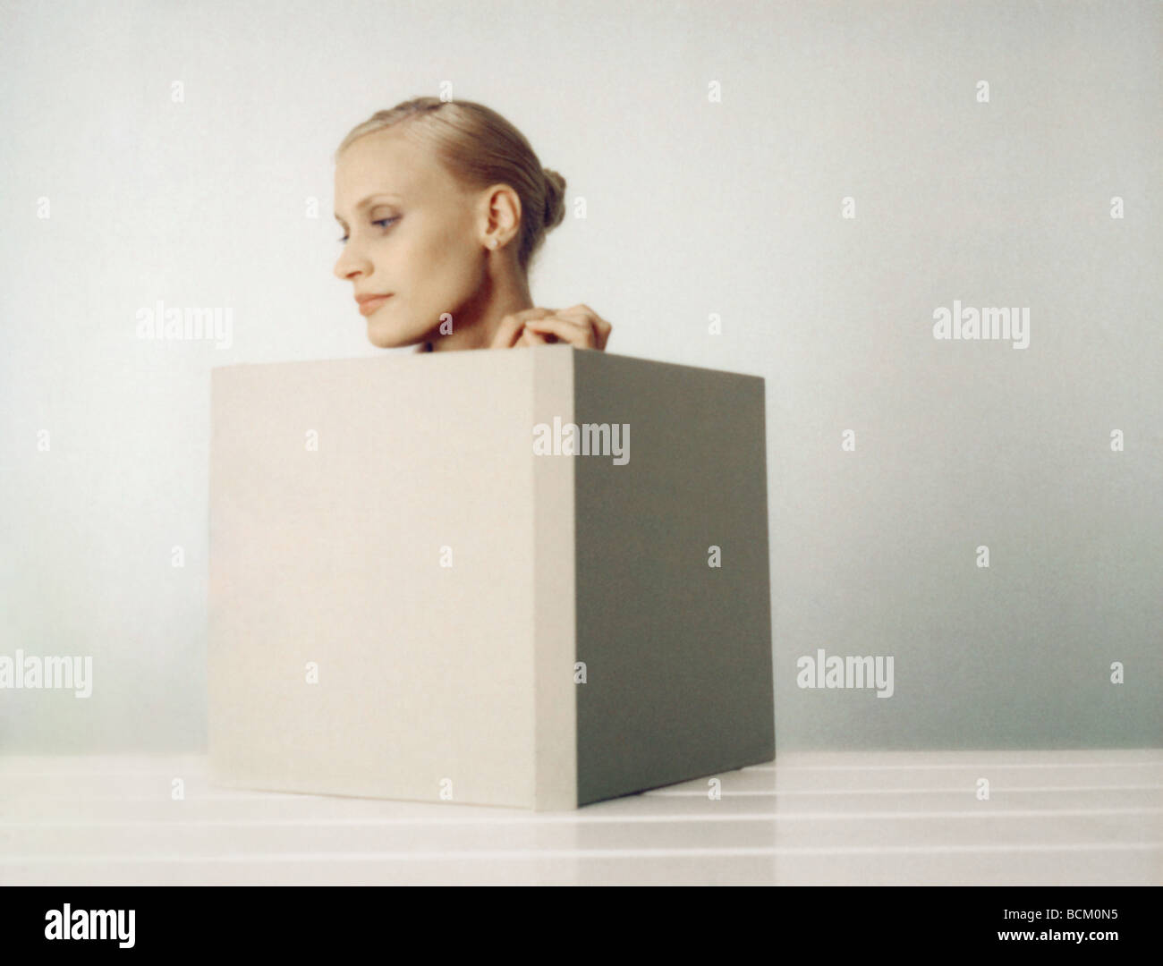 Woman sitting behind open book, looking away Stock Photo - Alamy