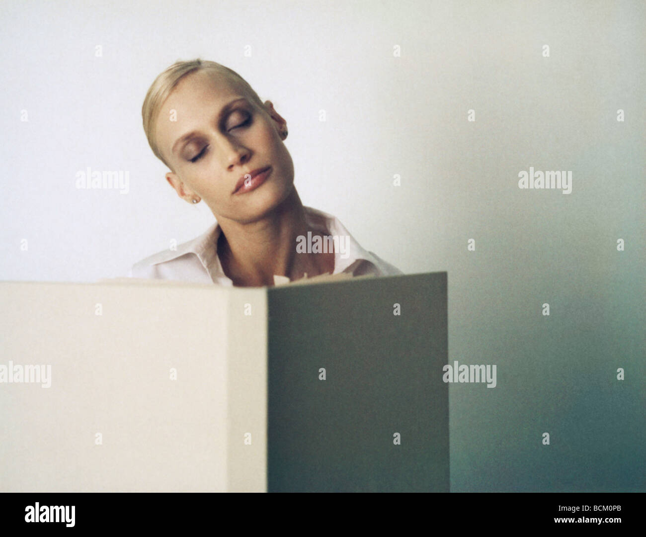 Woman behind open book, with tilted head and eyes closed Stock Photo ...
