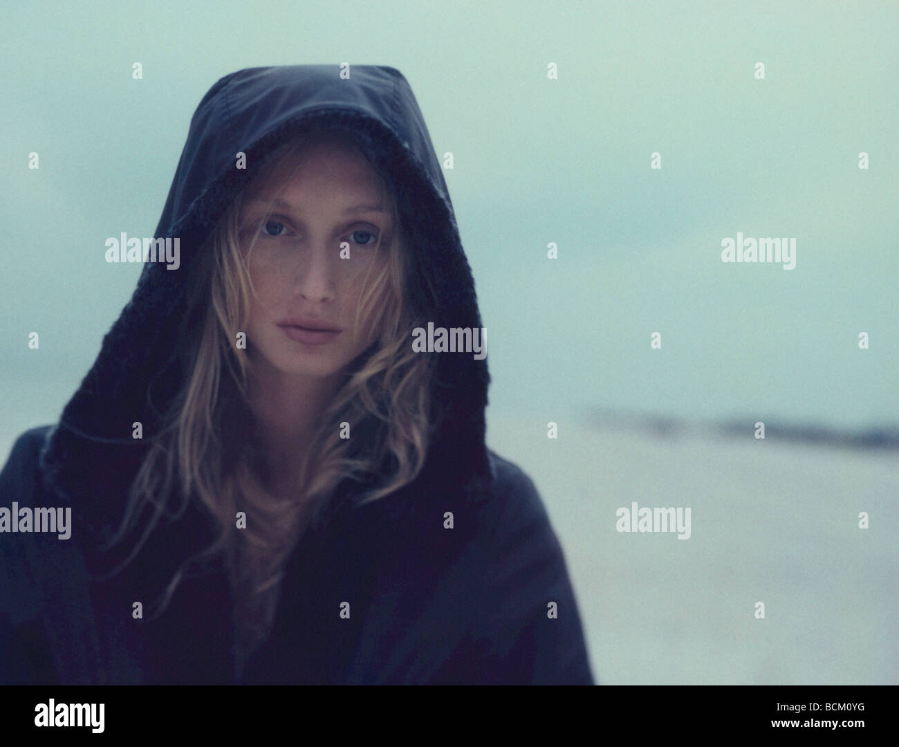 Close-up of young female wearing hood, looking at camera, portrait ...