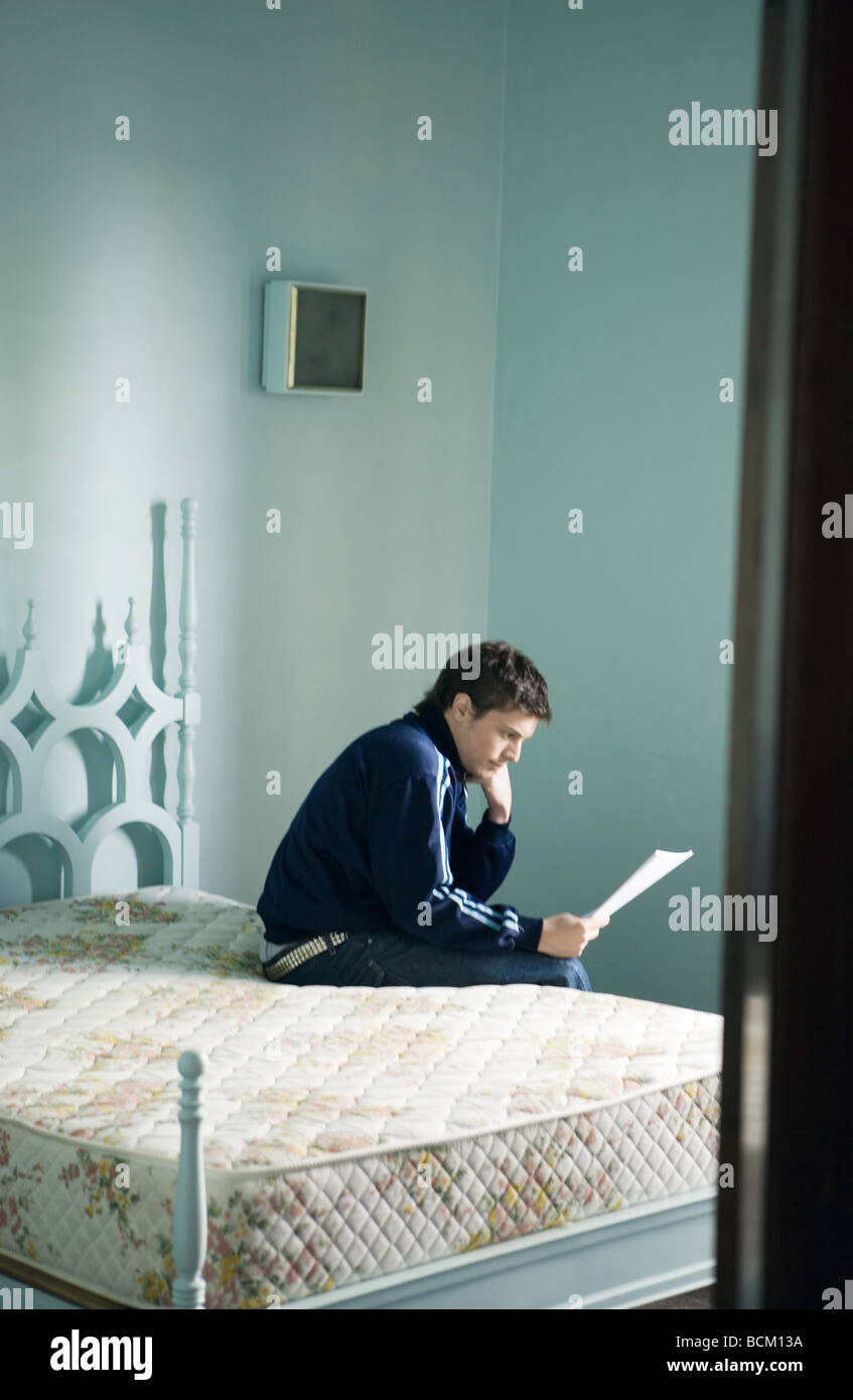 Young man sitting on edge bed hi-res stock photography and images - Alamy