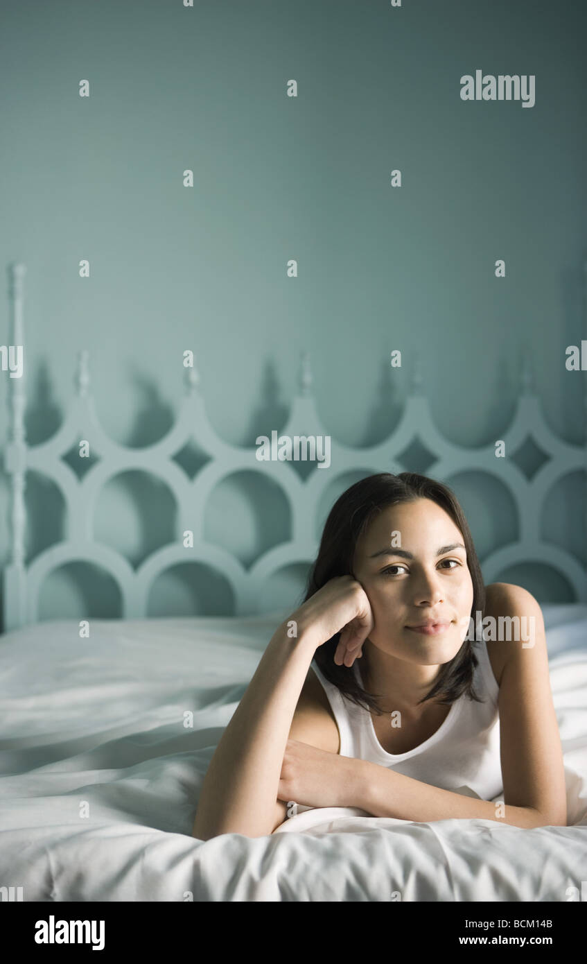 Woman lying on bed, smiling at camera Stock Photo - Alamy