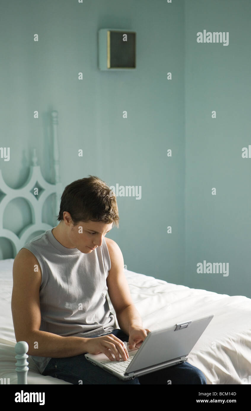Young man sitting on edge bed hi-res stock photography and images - Alamy