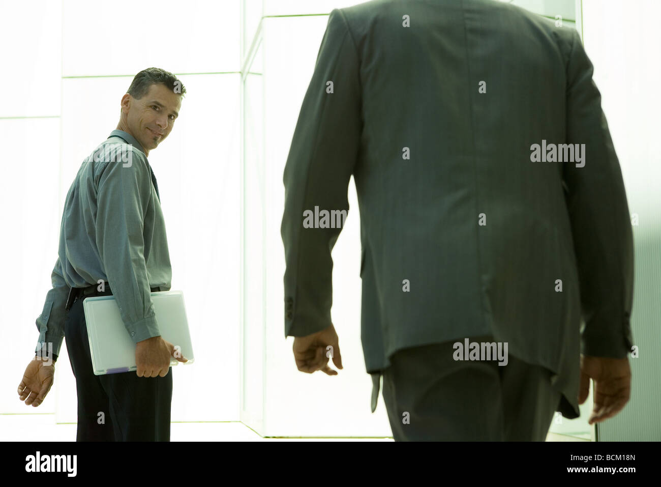 Businessman looking over shoulder at colleague, rear view Stock Photo ...