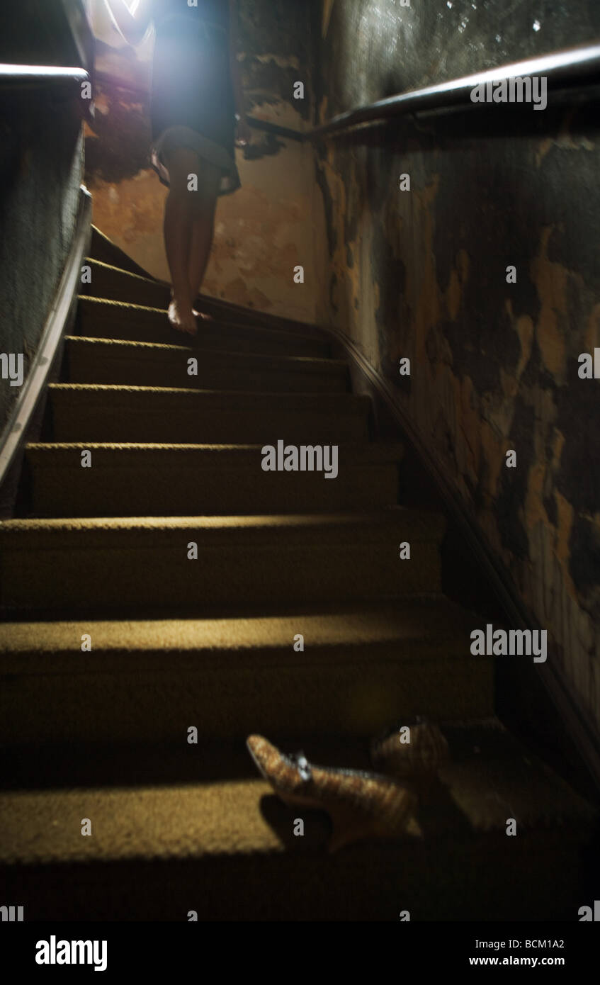 Woman going down spiral stairs hi-res stock photography and images - Alamy
