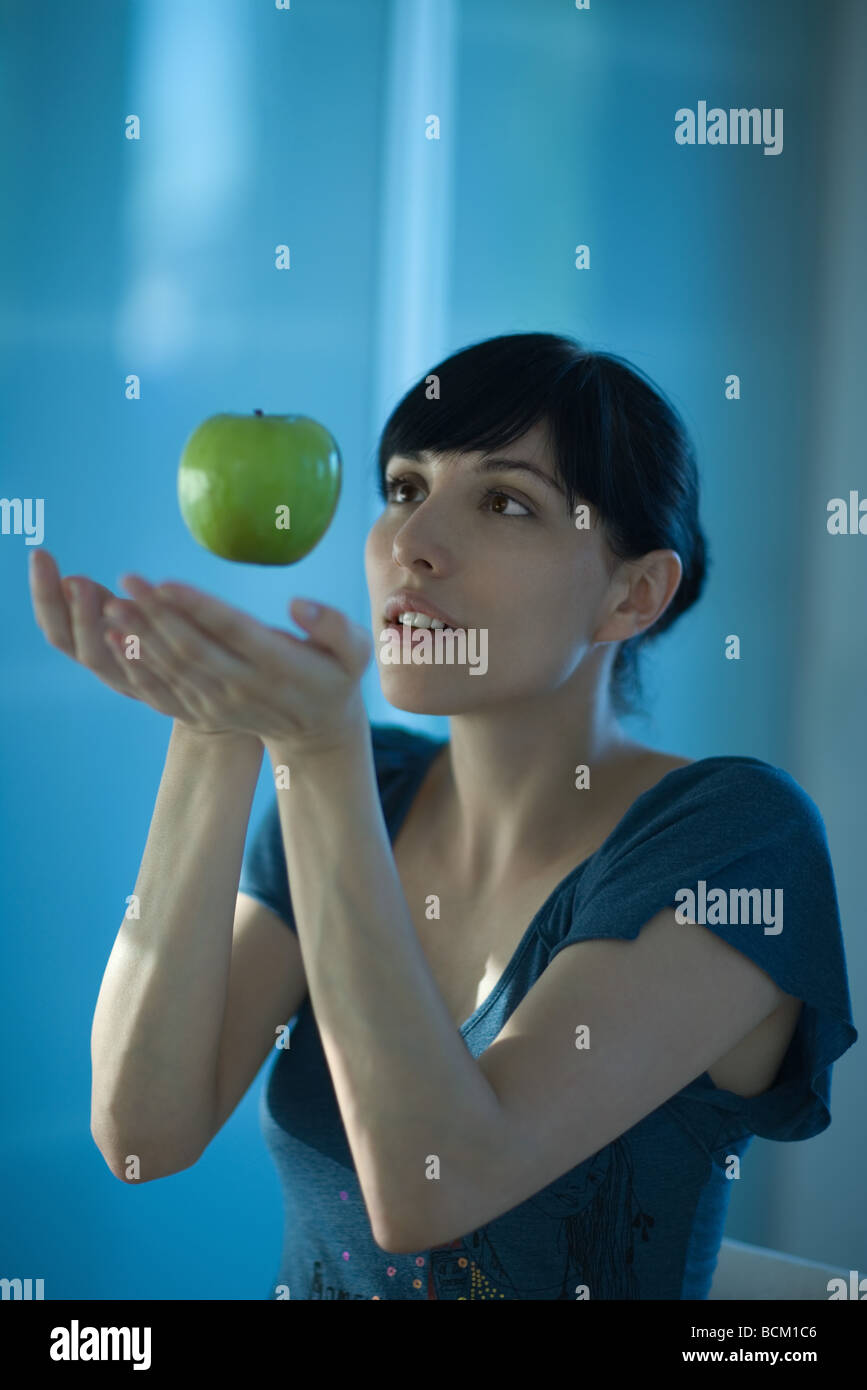 Apple floating in air above woman's hands Stock Photo - Alamy