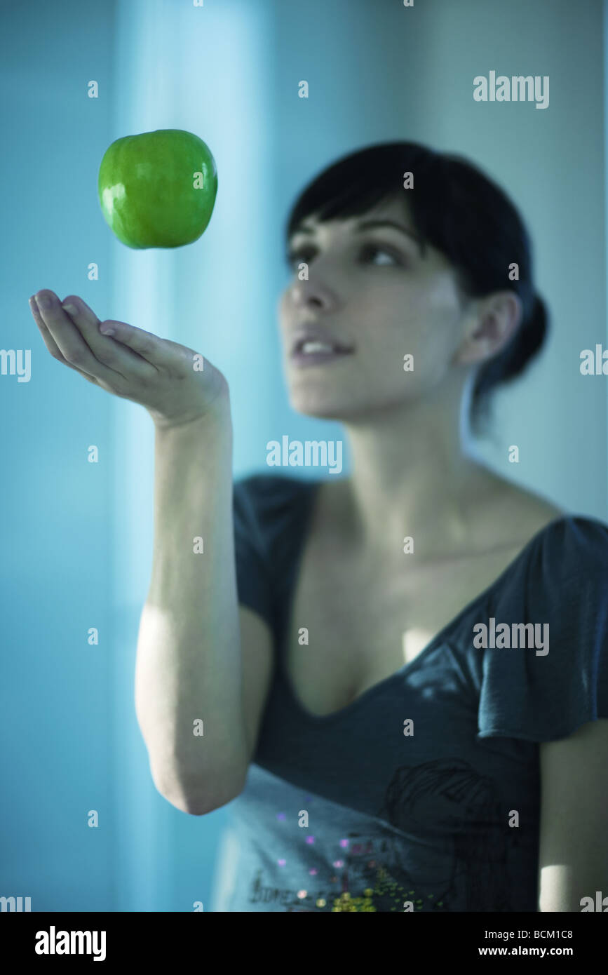 Apple floating in air above woman's hand Stock Photo - Alamy