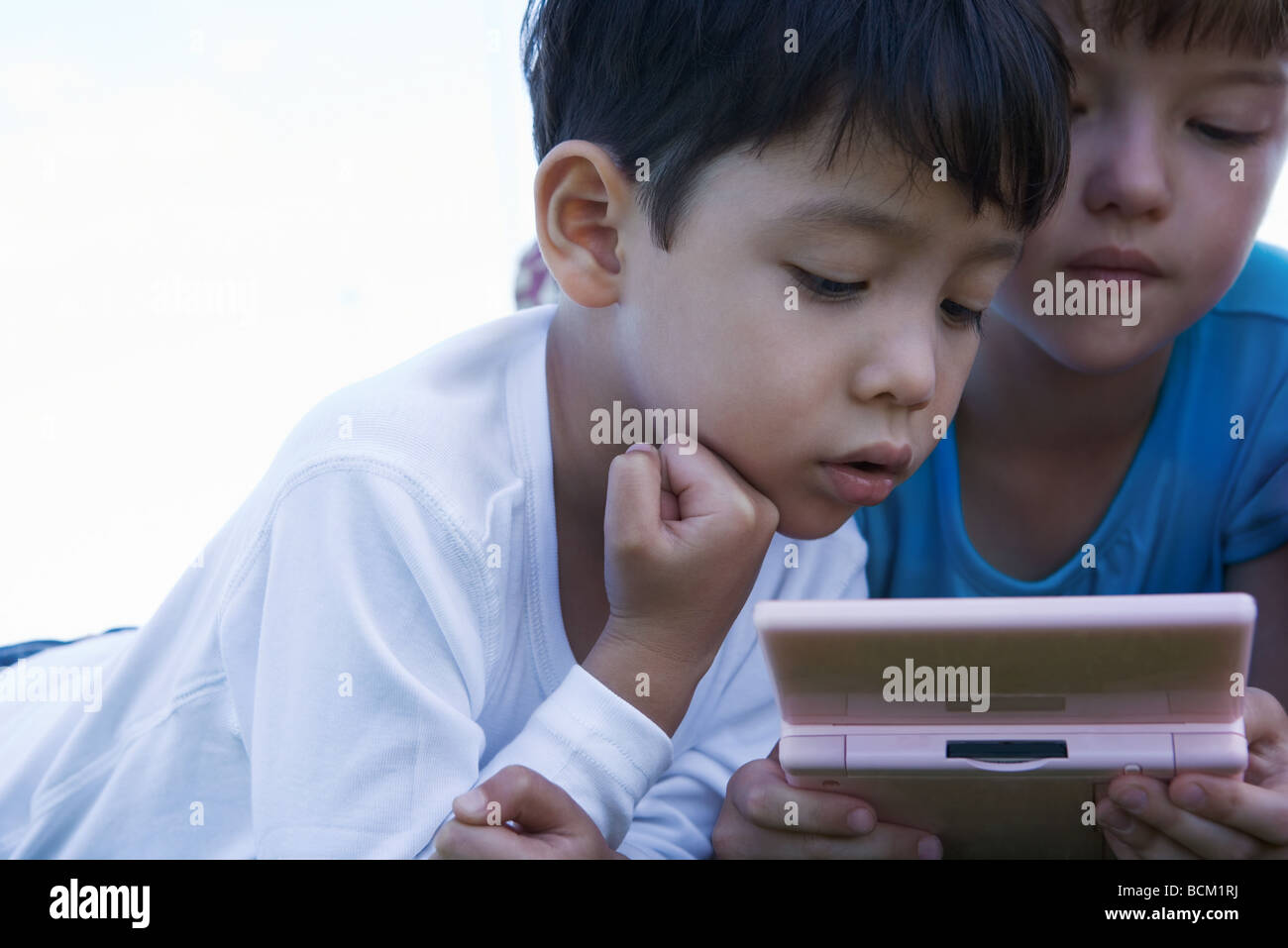 Kids playing handheld video game hi-res stock photography and images ...