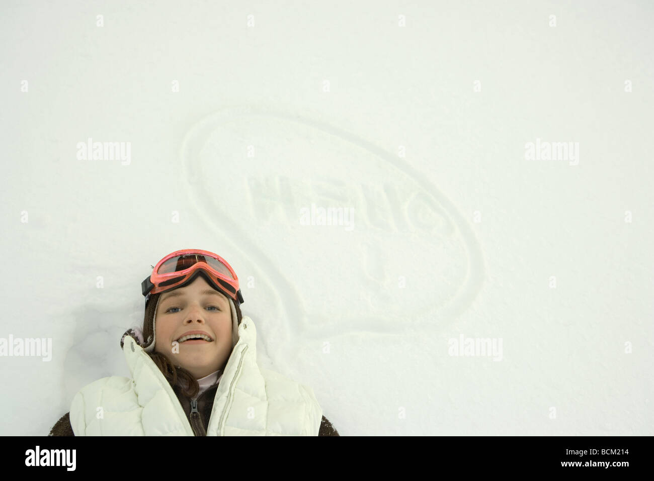 Teenage girl lying on snow next to thought bubble and the word "hello ...