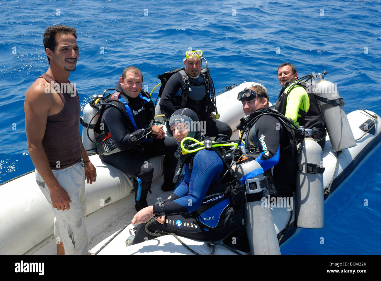 Group of men scuba divers sitting on an inflatable boat hi-res stock ...