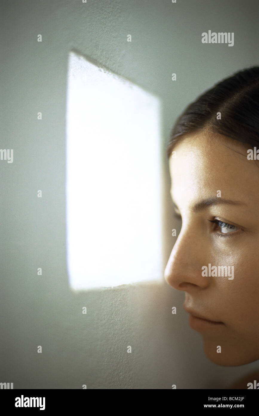 Woman peeking out small window, close-up Stock Photo - Alamy