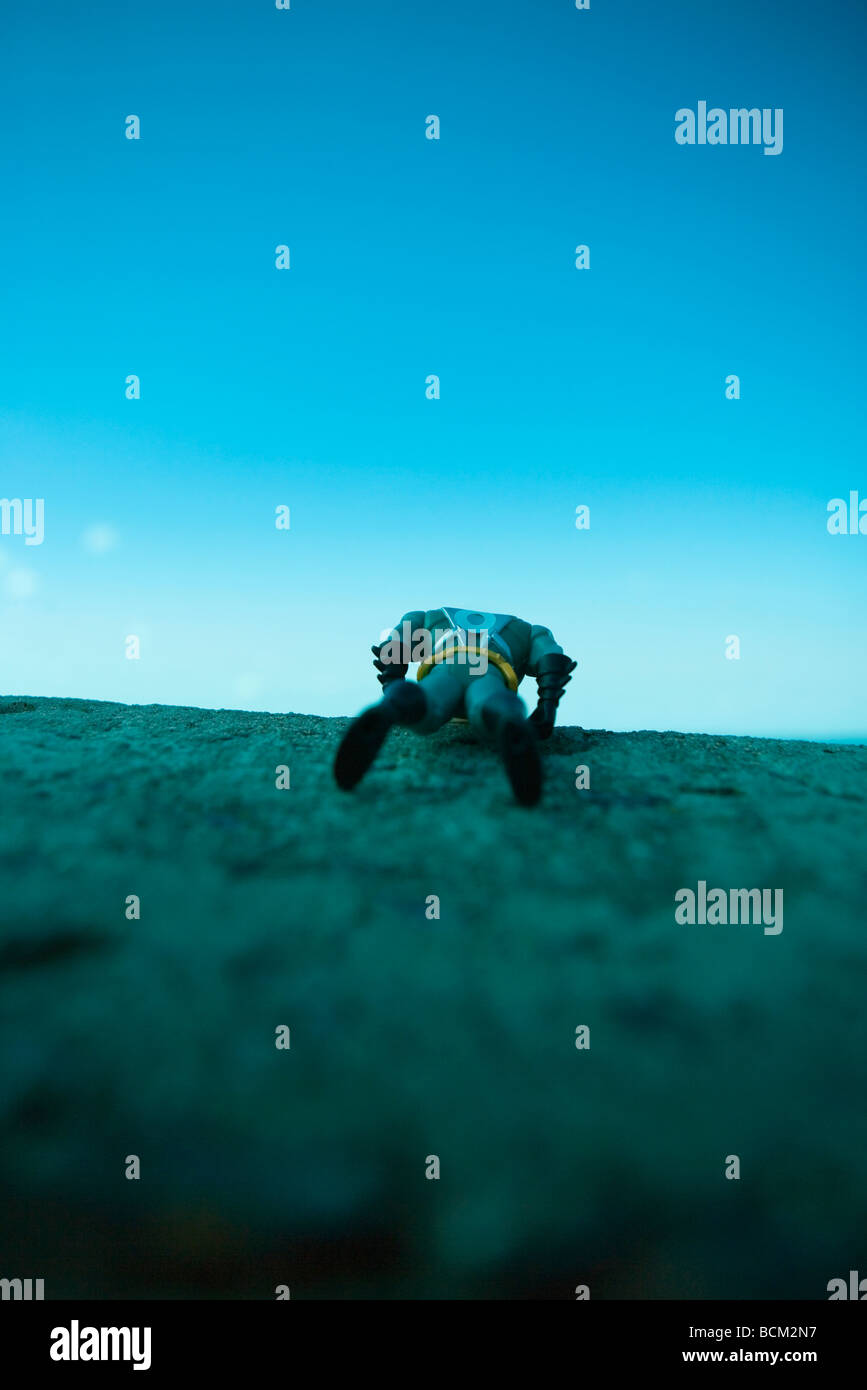 Action figure hanging from stone ledge, low angle view Stock Photo - Alamy