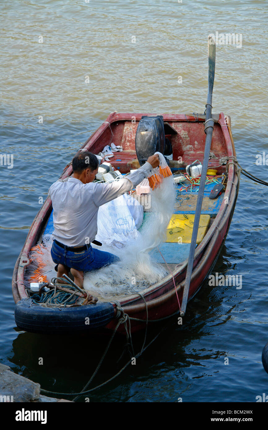 Fisherman sorting his fish net Hong Kong China Stock Photo - Alamy