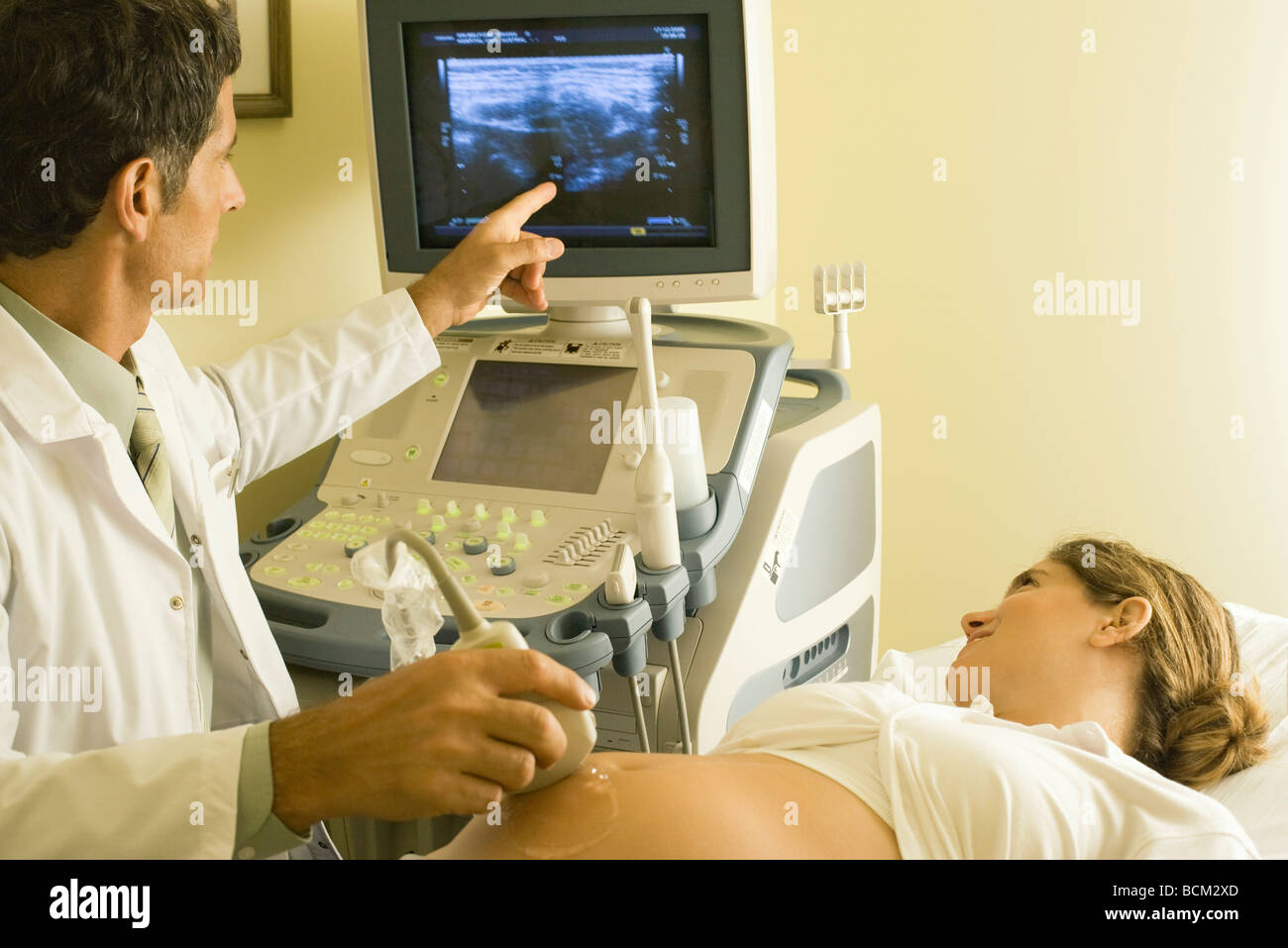 Cropped image of doctor performing ultrasound on pregnant woman in ...